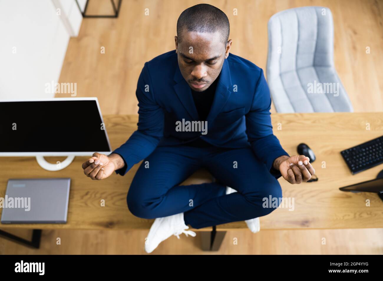 African American Male Meditation In Office Near Computer Stock Photo ...