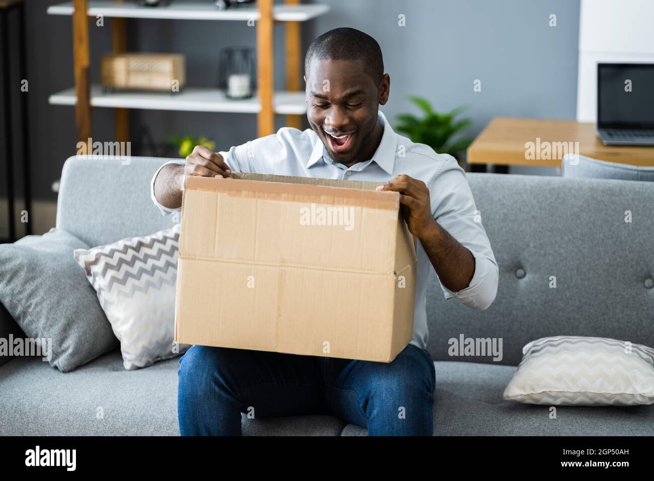 Happy African Opening Package. Receiving Parcel Gift Stock Photo - Alamy