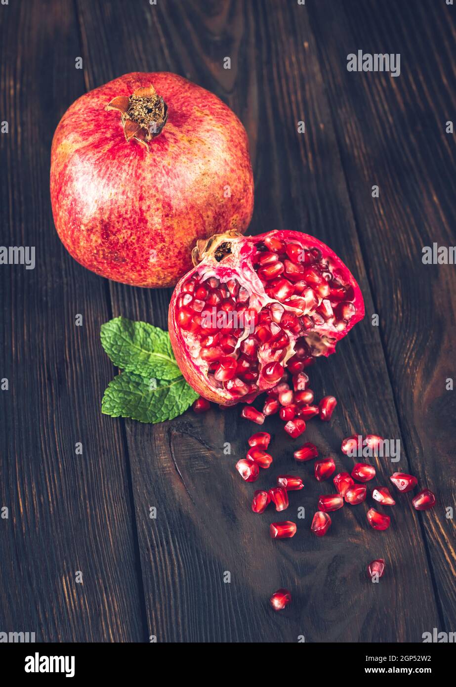 Fresh pomegranate on the wooden table: cross section Stock Photo - Alamy