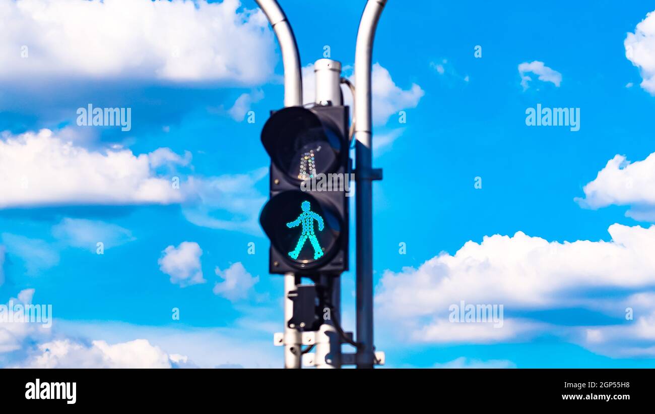 Green traffic light signal for pedestrians on the crosswalk against ...