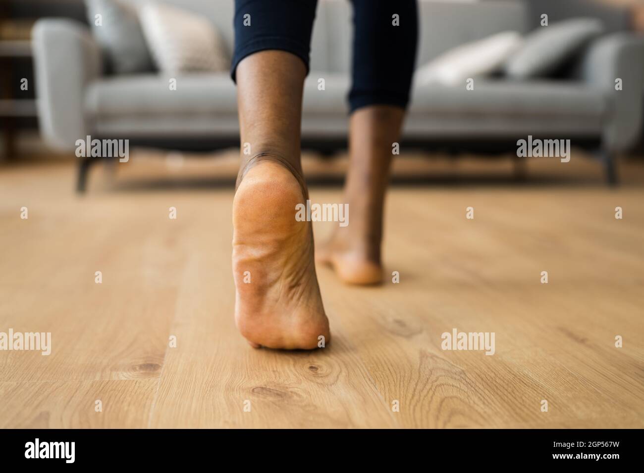 African Barefoot Woman Walking On Heated Floor In Living Room Stock ...