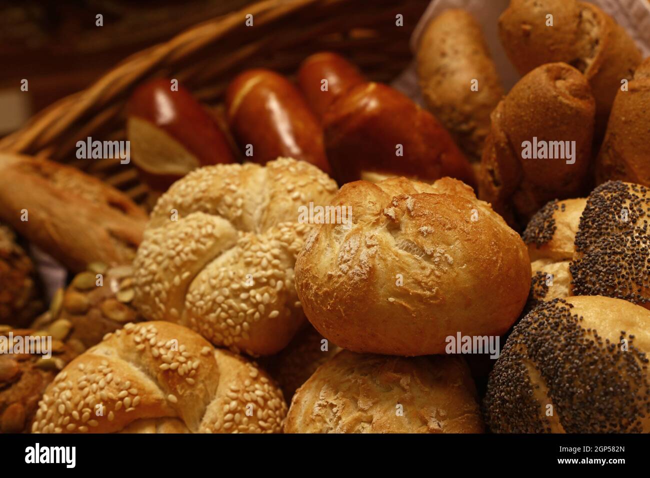 Close up several assorted fresh bread buns in basket on retail display ...