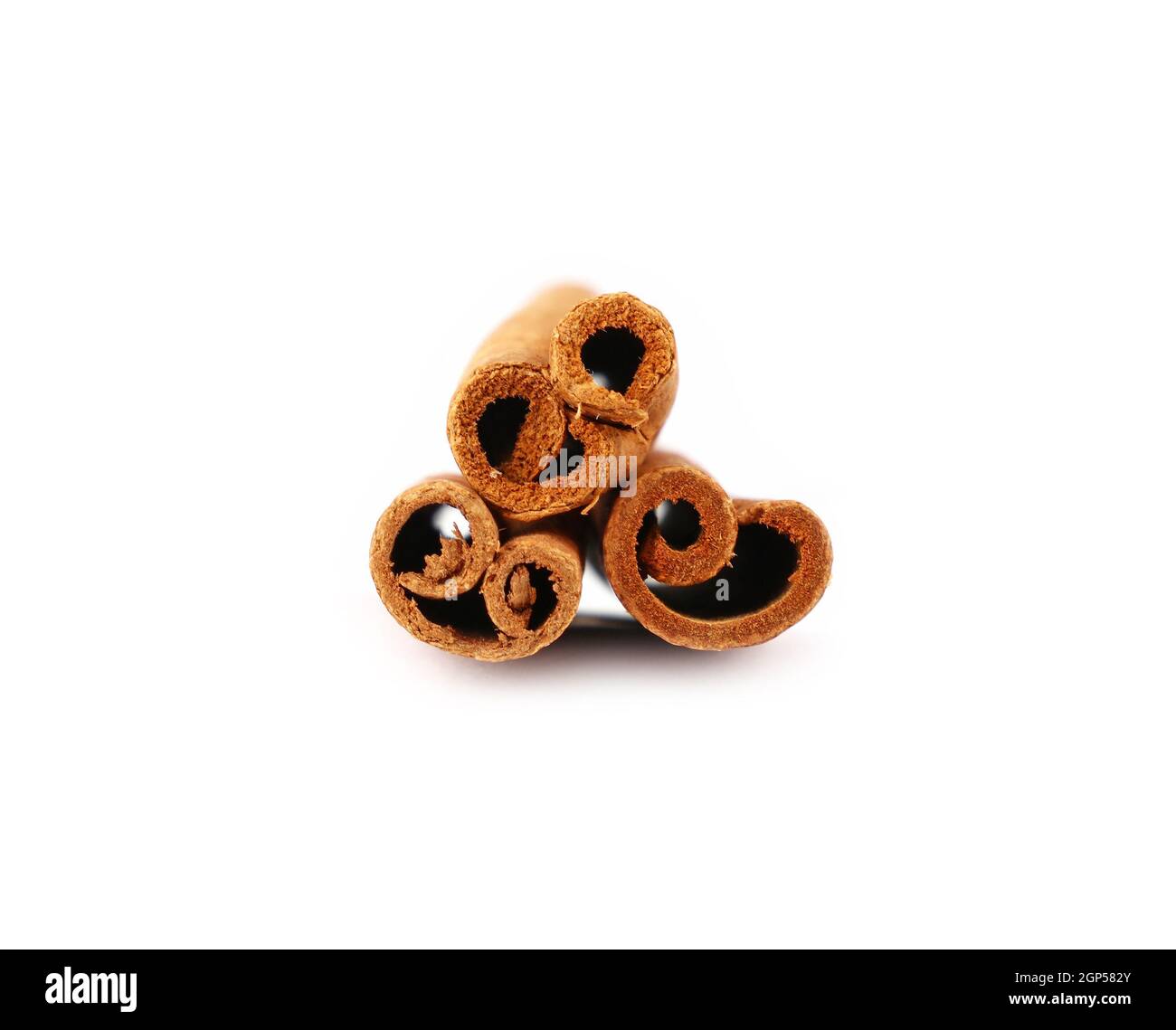 Close up heap of three cinnamon sticks isolated on white background ...