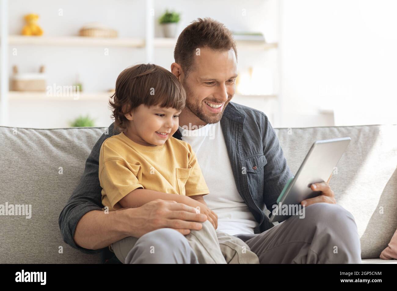 Modern technologies and kids development. Happy young father watching ...