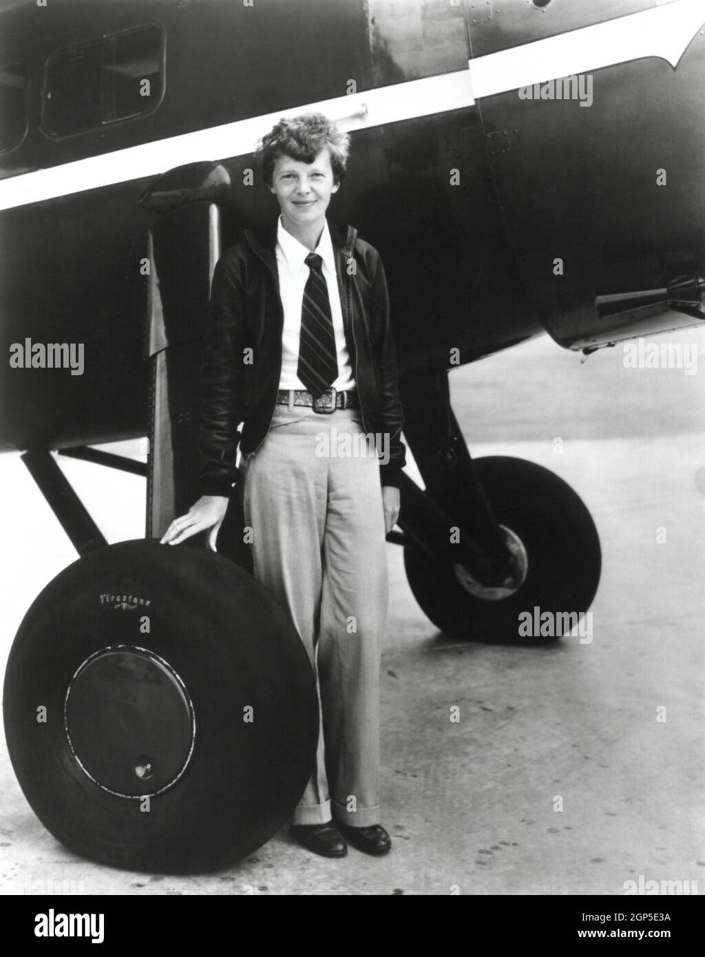 Aviator, Amelia Earhart, standing below her Bright Red Lockheed Vega ...