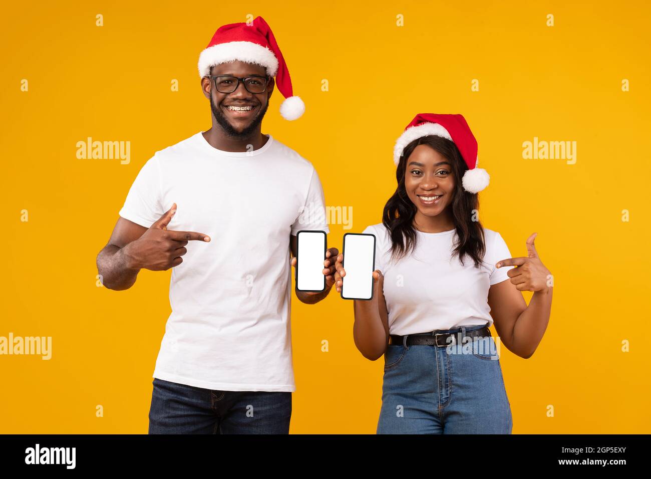 Black Couple In Santa Hats Showing Phones With Empty Screens For ...