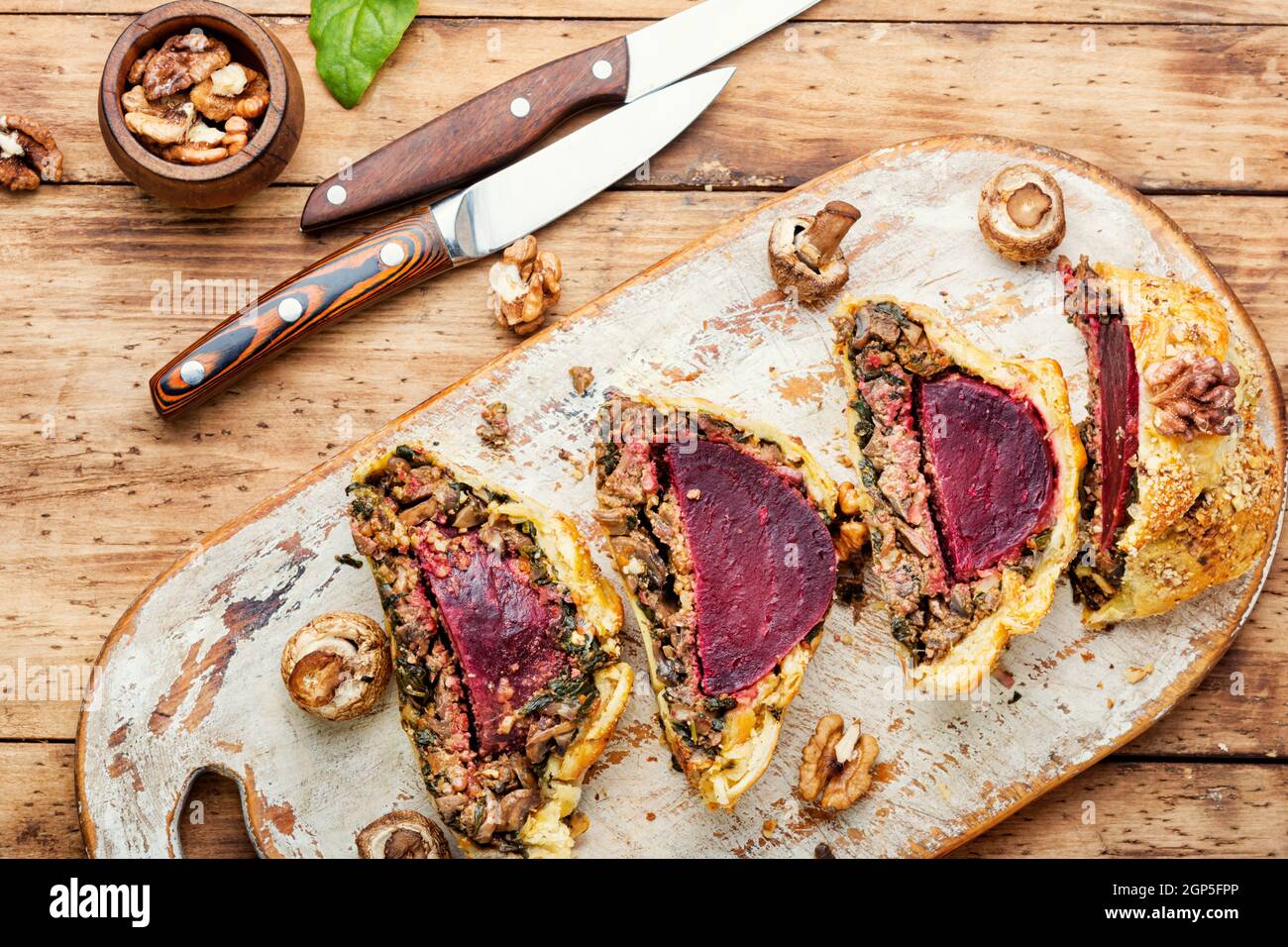 Delicious beetroot pie sliced on a kitchen board.Sliced pie Wellington ...