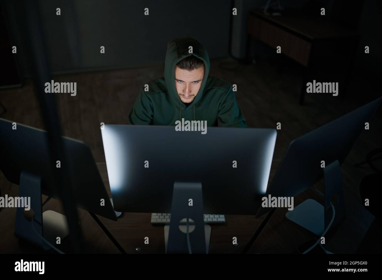 Hacker in black hoodie works hi-res stock photography and images - Alamy