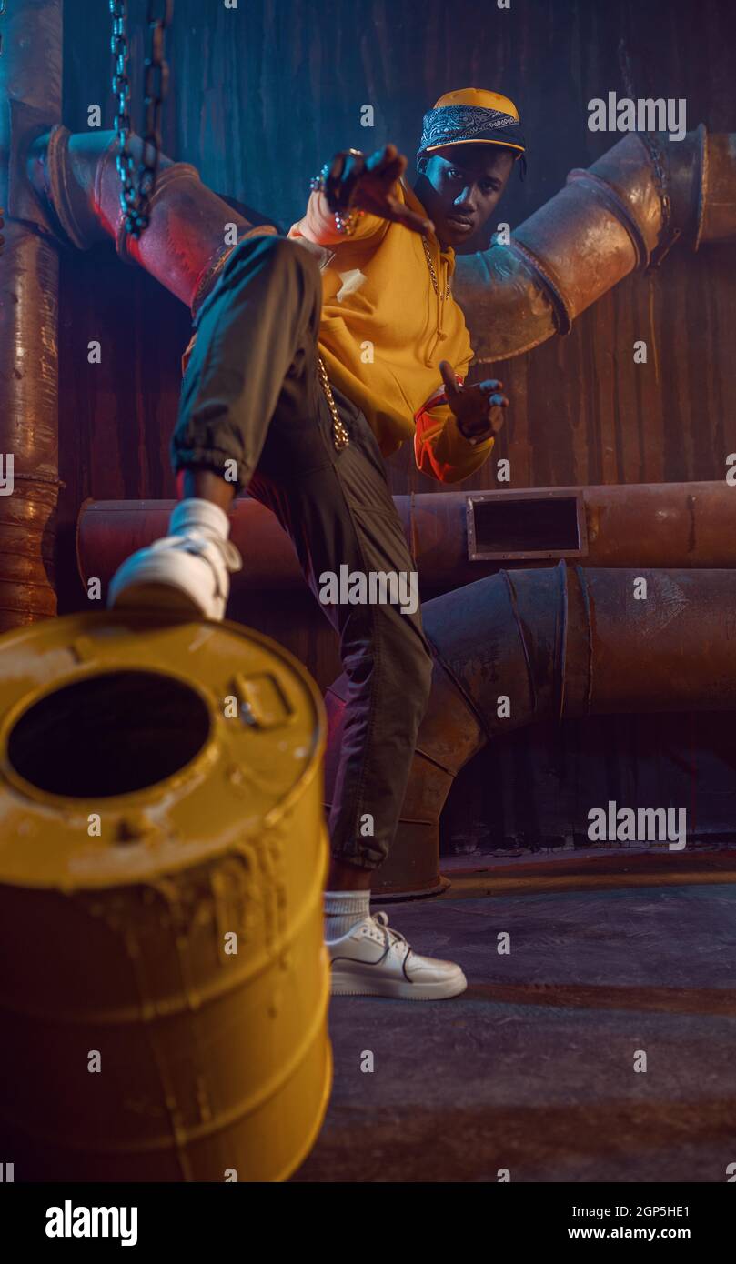 Young rapper in yellow hoodie poses in studio with cool underground ...