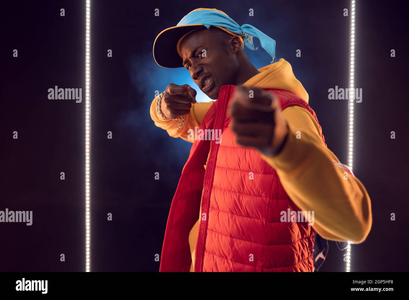 Young stylish rapper poses in studio with linear illumination. Hip-hop ...