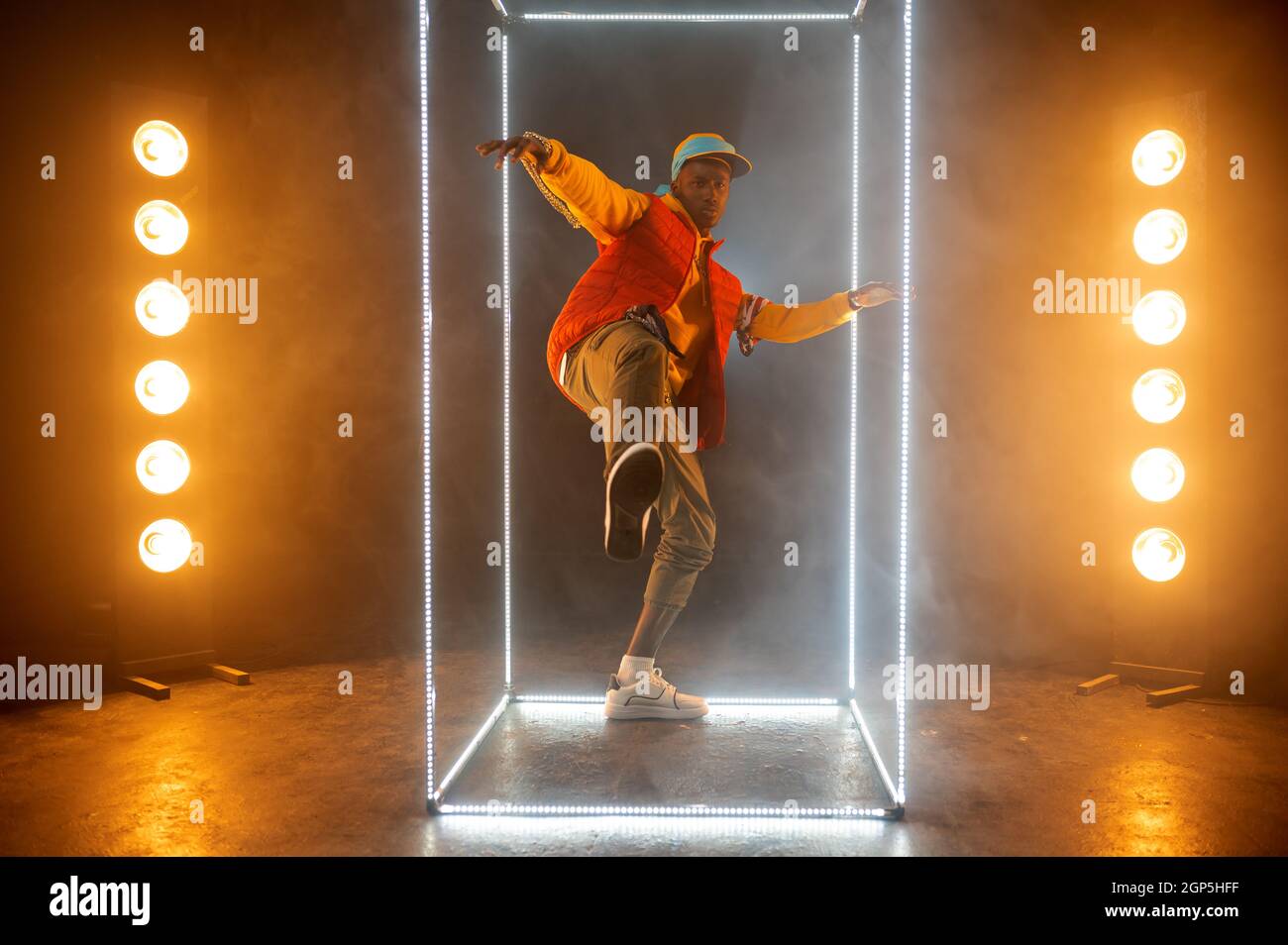 Stylish rapper on the stage with illuminated cube. Hip-hop performer ...