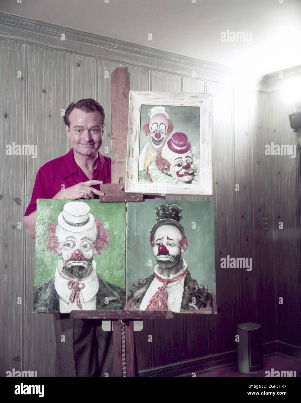 Red Skelton posing with some of his clown paintings, circa 1950s Stock ...
