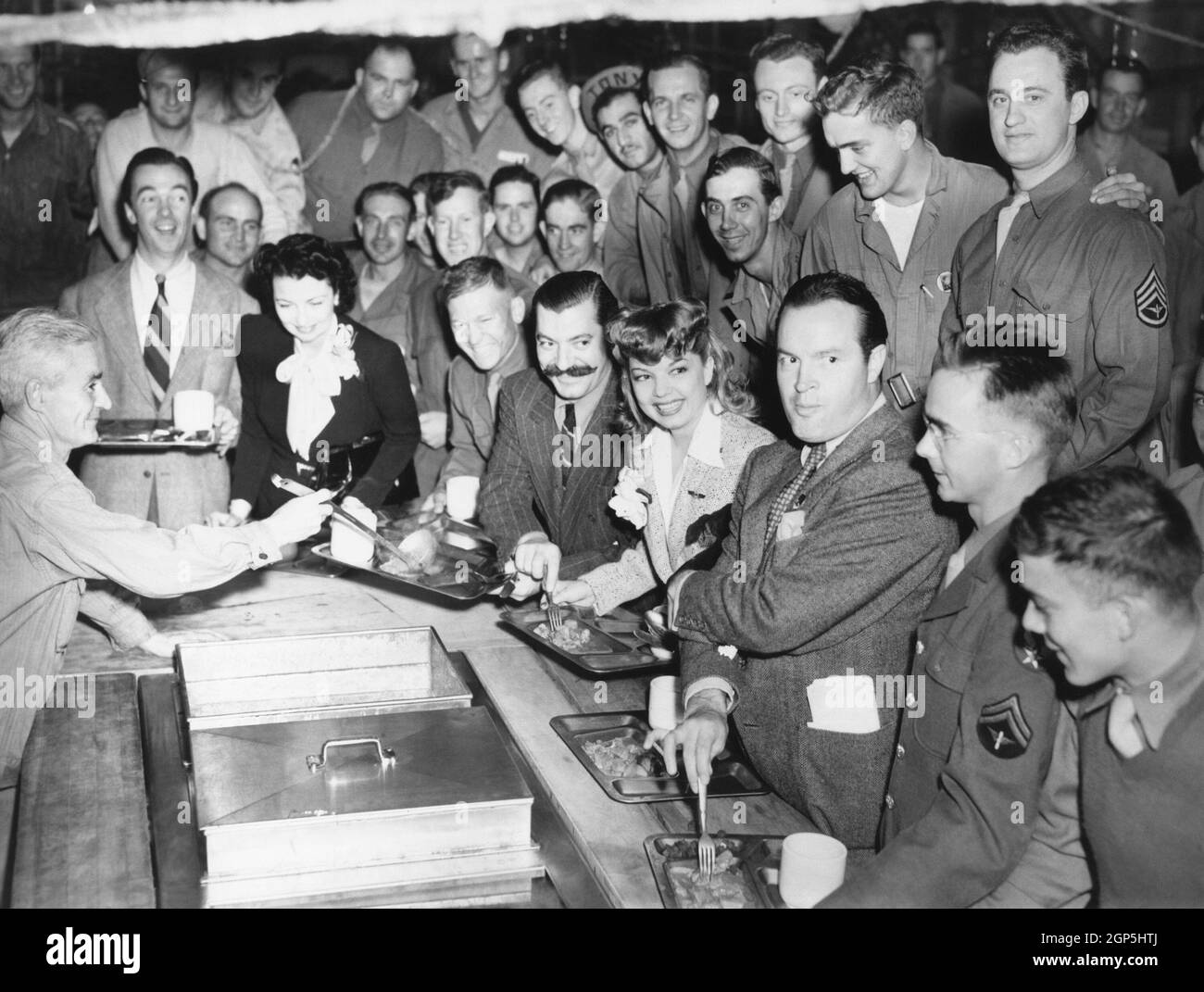With U.S> soldiers in mess hall during USO tour, seated, starting third ...