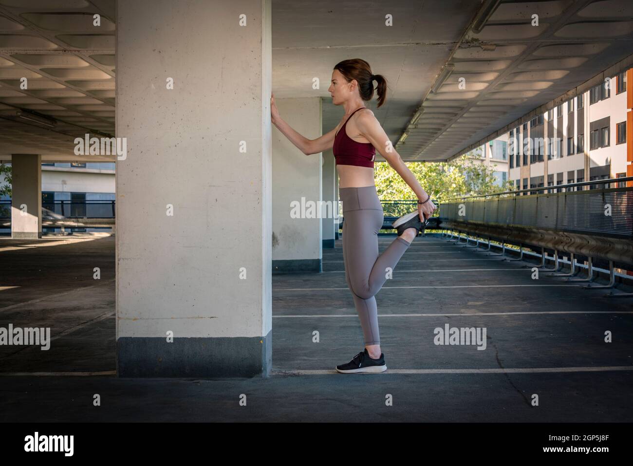 Female runner warming in an urban parking lot Stock Photo - Alamy