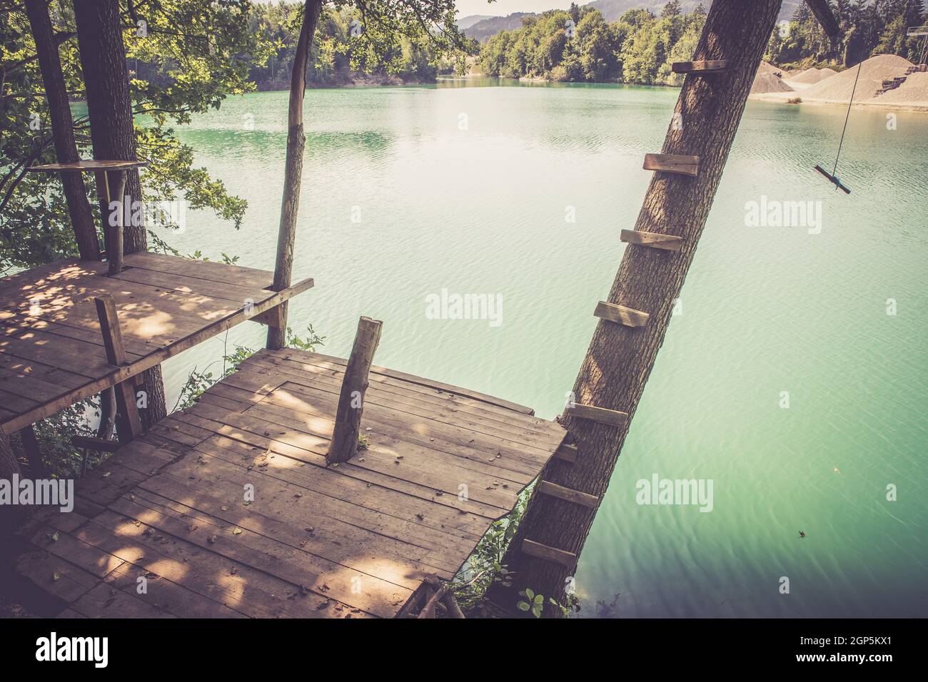 Treehouse wooden platform at a beautiful blue lake Stock Photo - Alamy