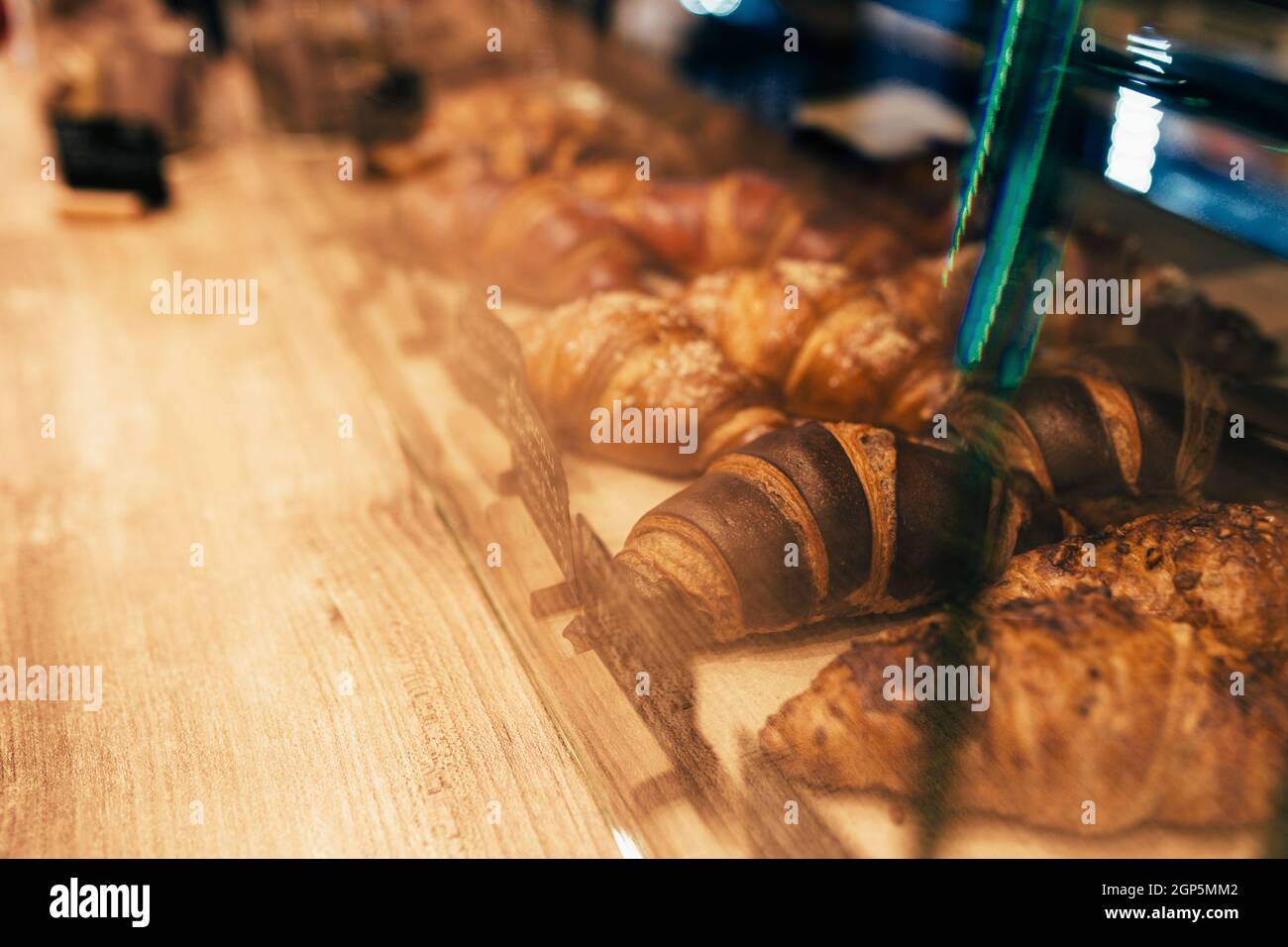 The waiter pulls out croissants in a cafe window. Blurred background ...