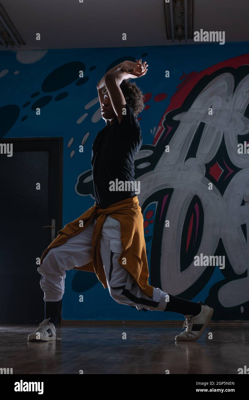 African American hip hop dancer (breakdancer) performing over graffiti ...