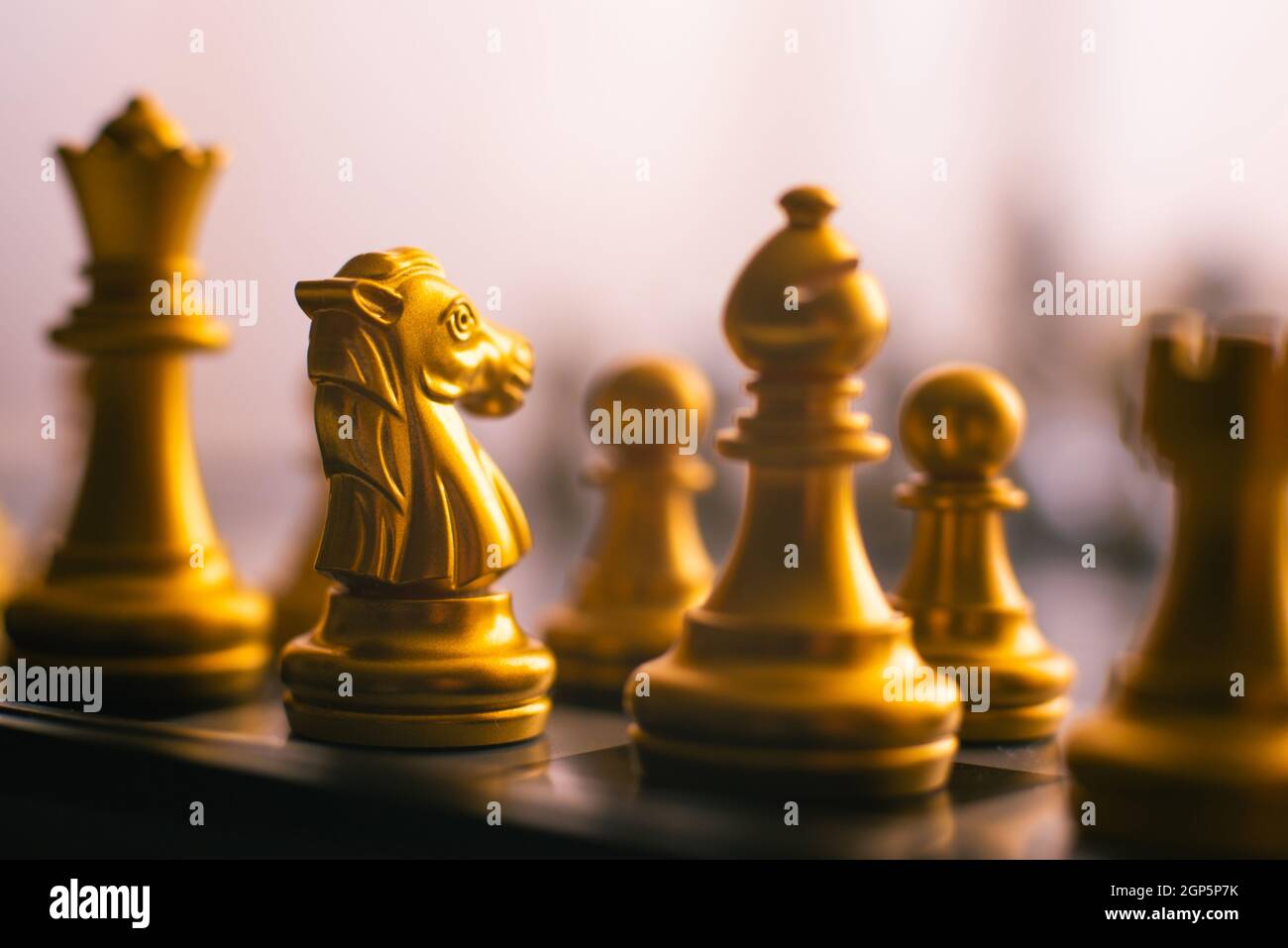 Chess pieces of gold color stand on the board close-up. Board game ...