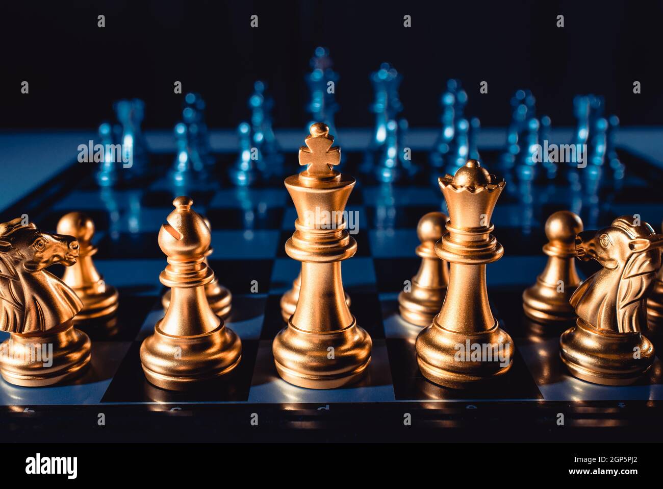 Chess pieces of gold color stand on the board close-up. Board game ...