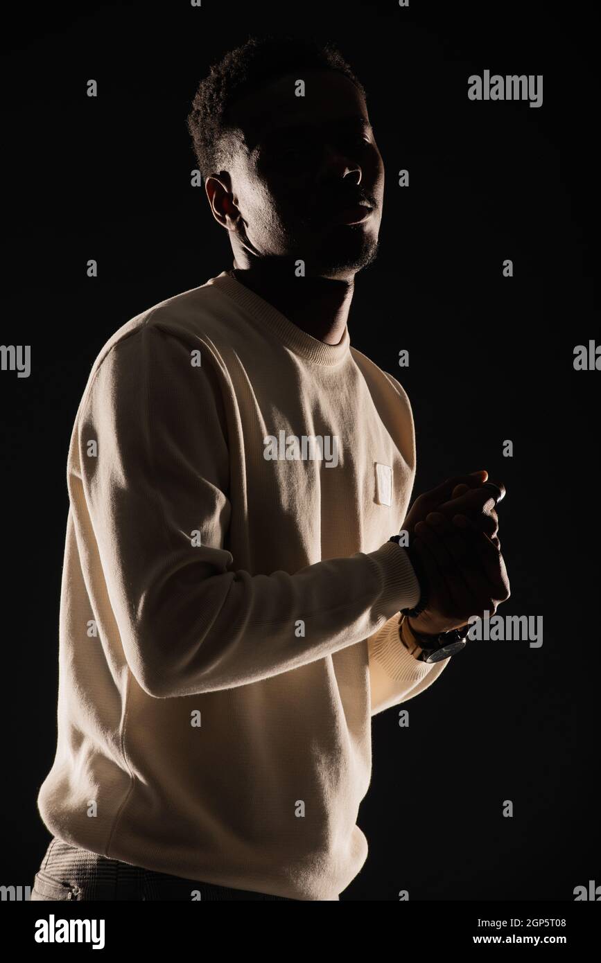 silhouette of young black amle is posing on dark background Stock Photo ...
