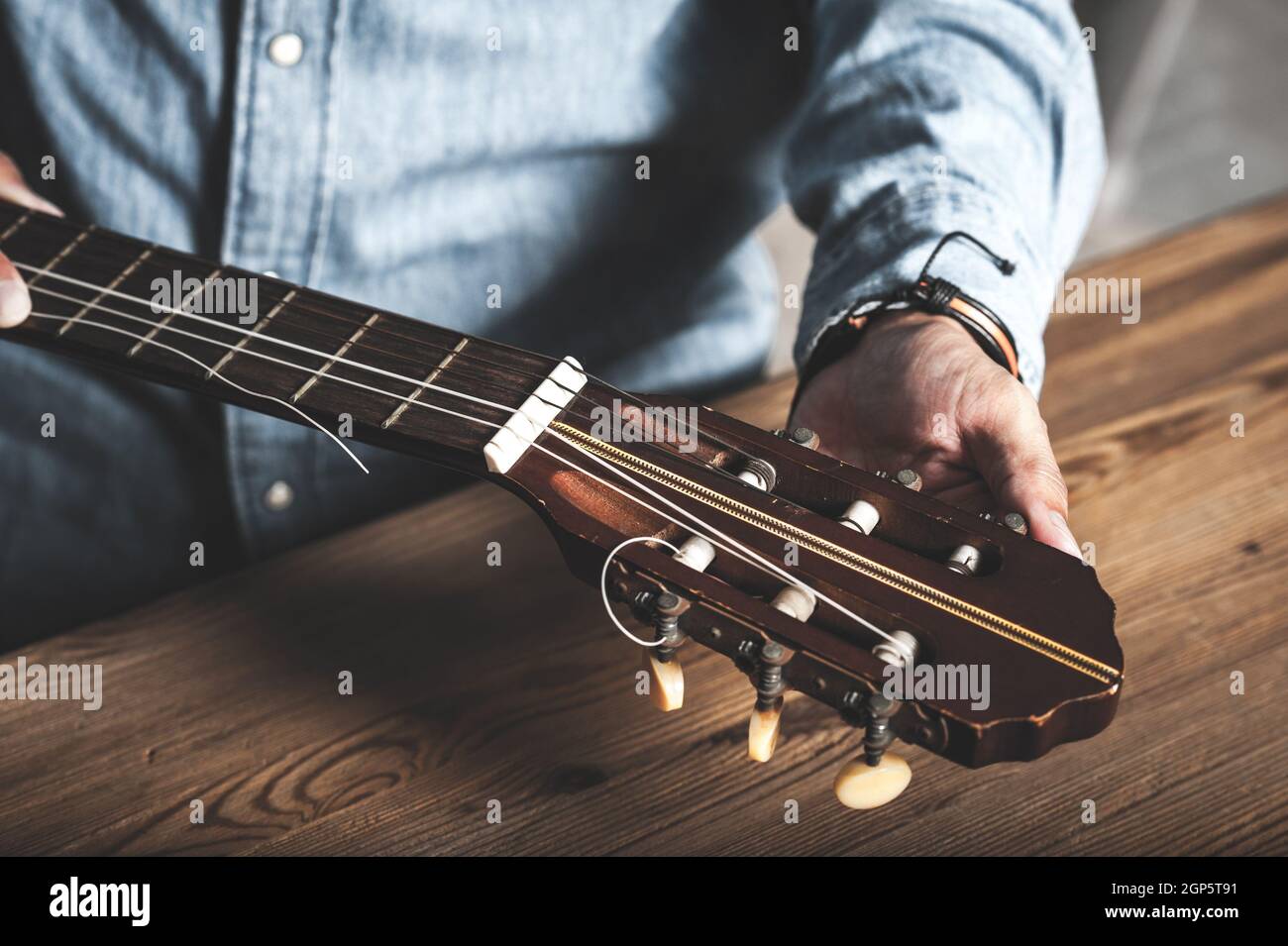 closeup the man showing breaked guitar strings Stock Photo - Alamy