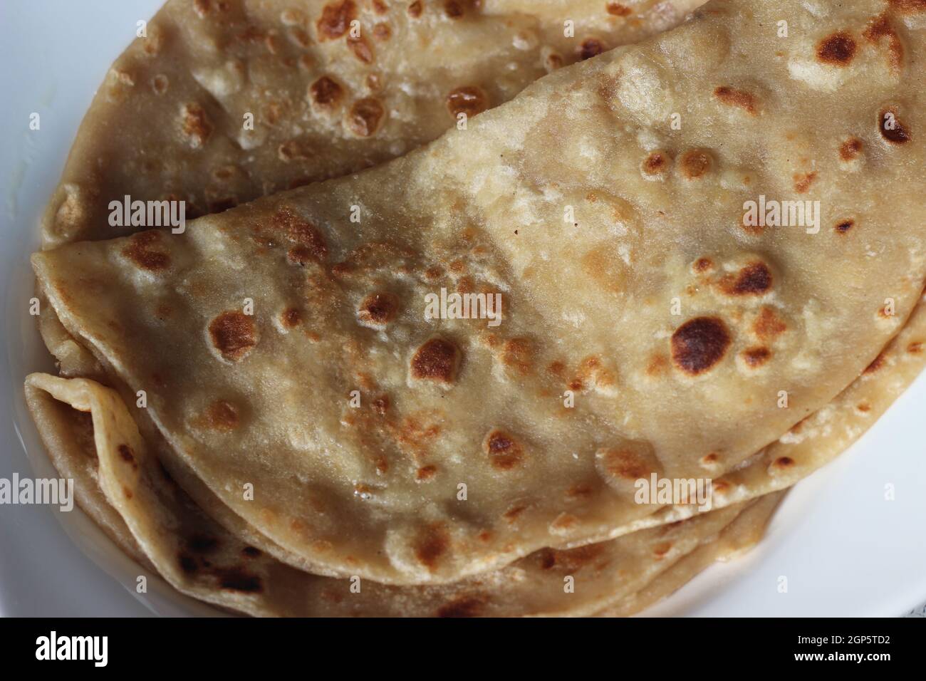 Closeup view of hand made plain bread in oil called paratha roti ...