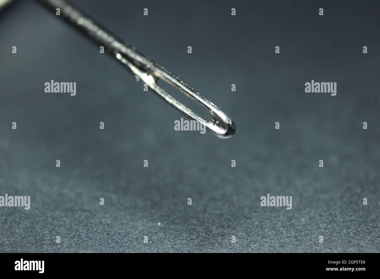 Macro photograph of sewing needle. Small needle with empty eyelet ...