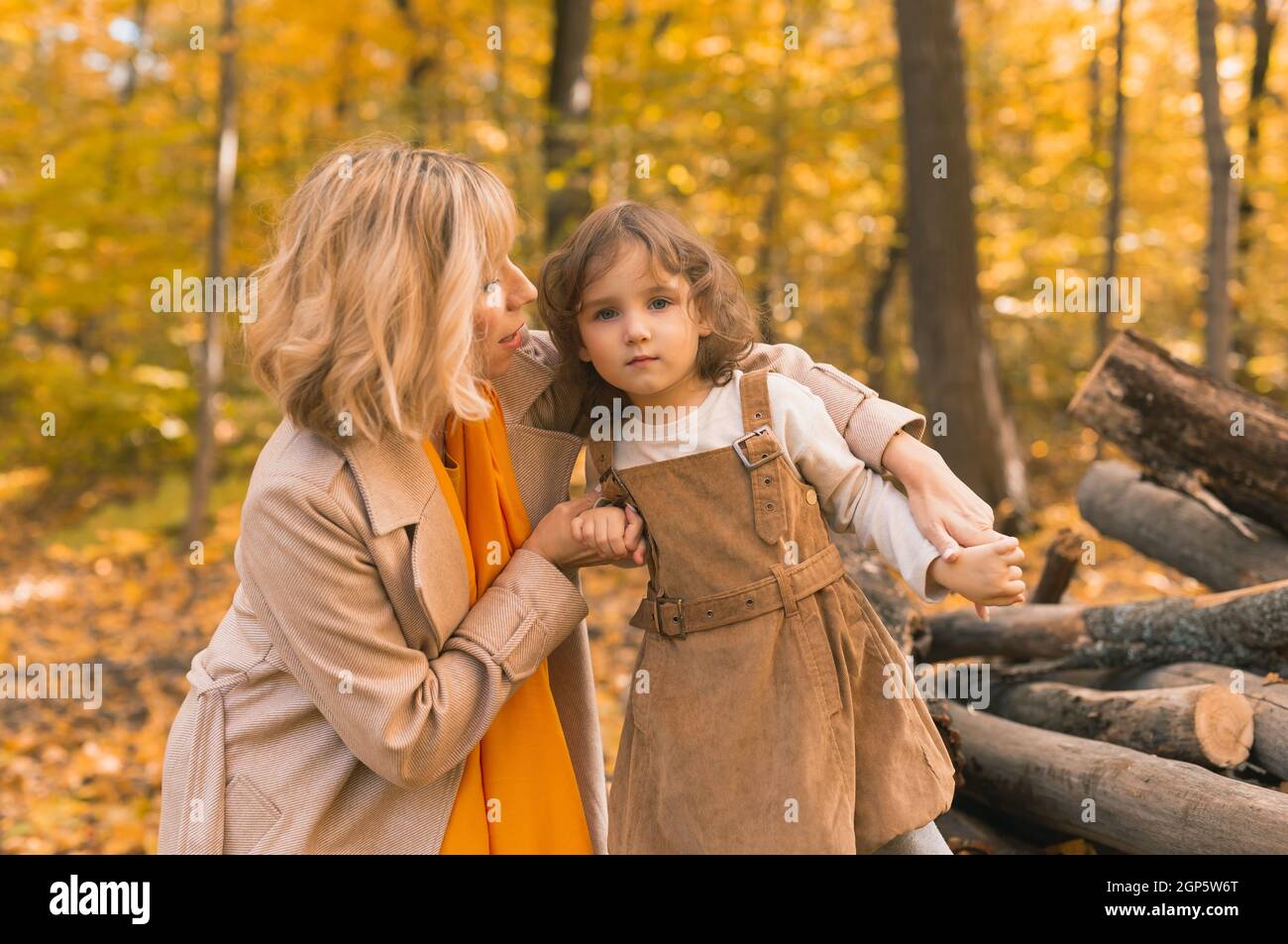 Young mother with her little daughter in an autumn park. Fall season ...