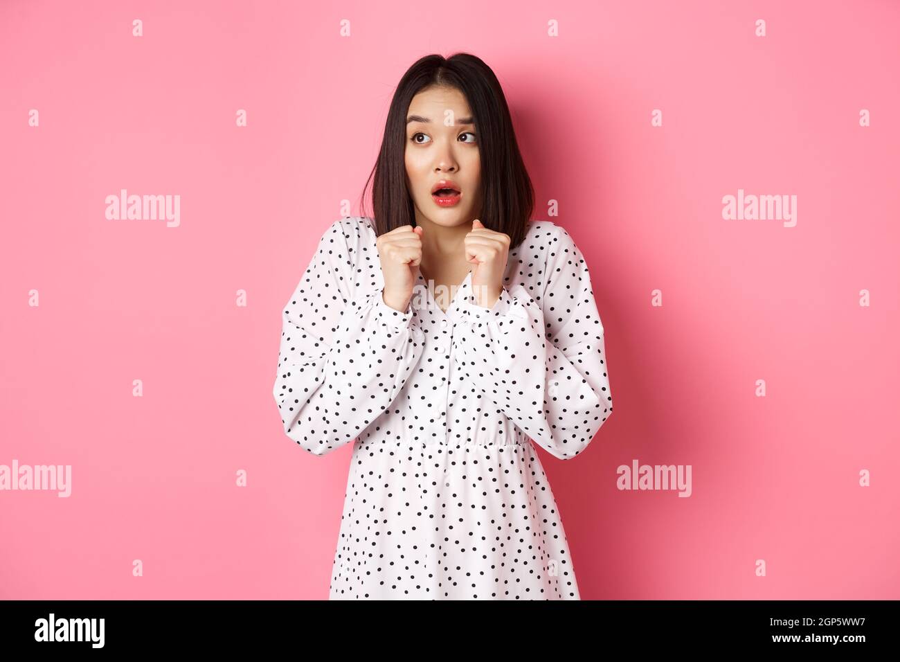 Scared and timid asian girl trembling from fear, staring left and ...