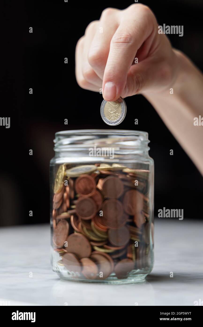 Hand dropping a coin. Saving and investment concept Stock Photo - Alamy
