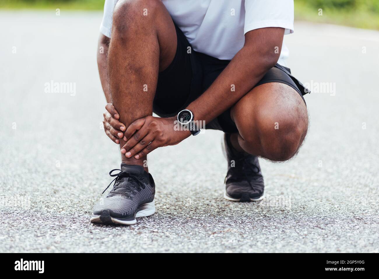 Close up Asian young sport runner black man wear watch hands joint hold ...