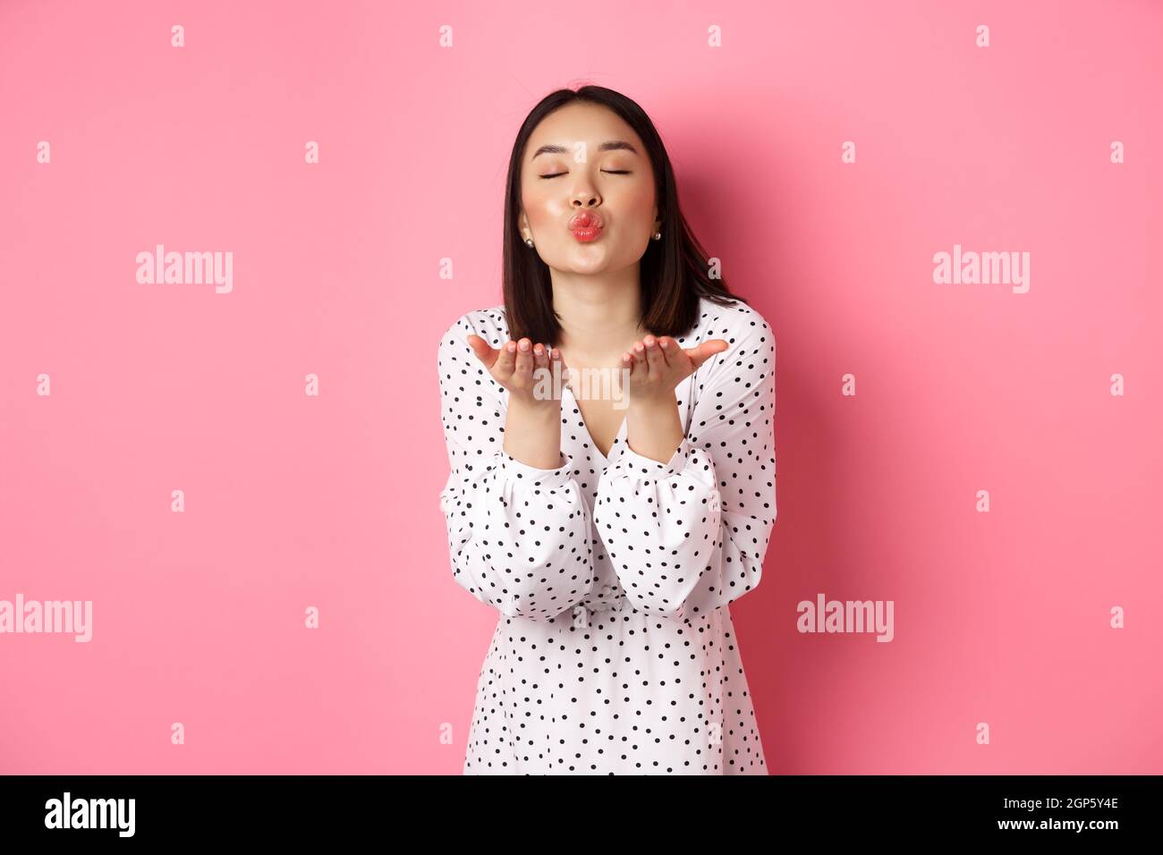 Beautiful chinese girl in dress blowing air kisses, sending mwah at ...