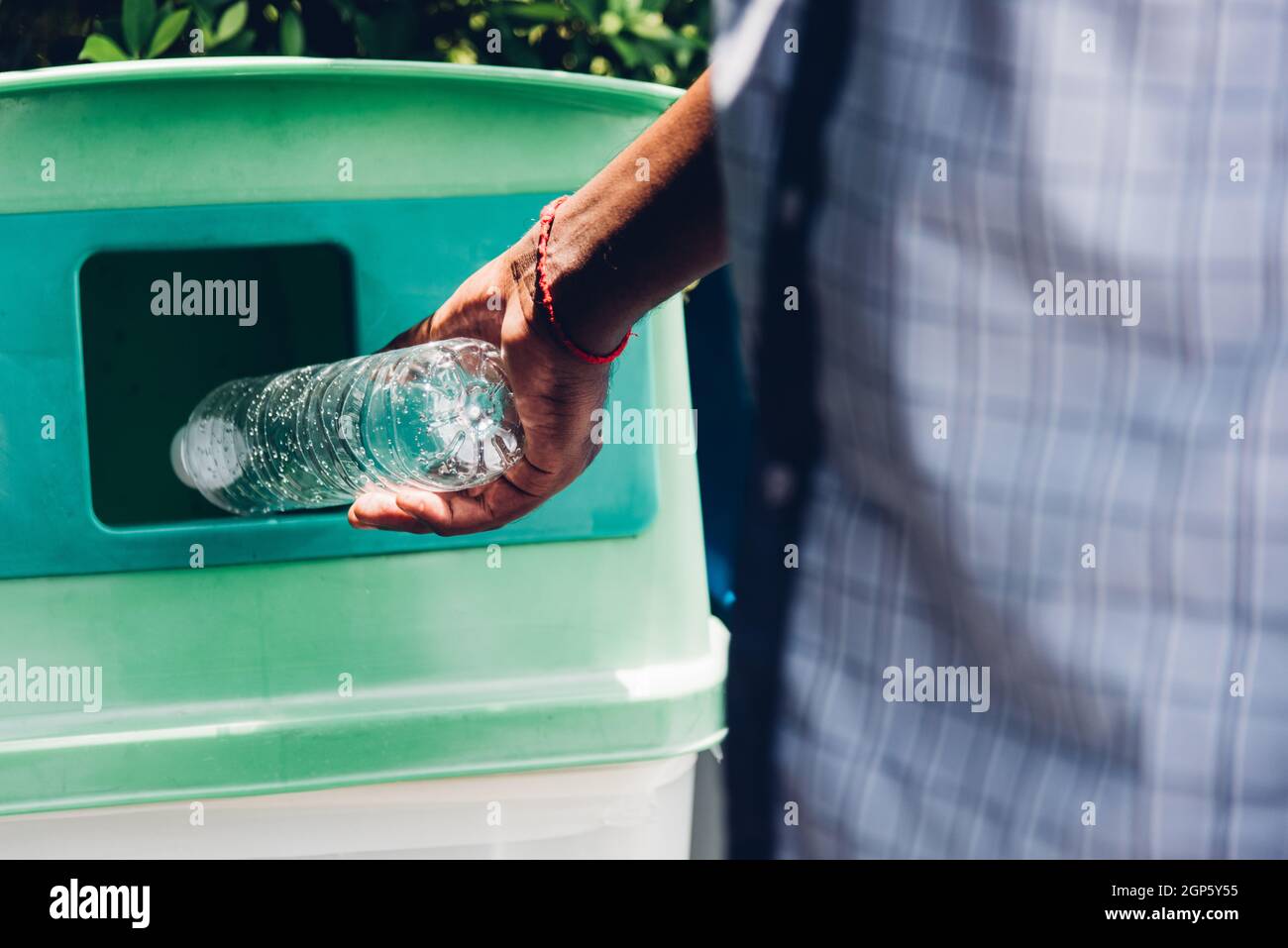 Selective focus close up the man black hand throwing an empty plastic water bottle in the ...