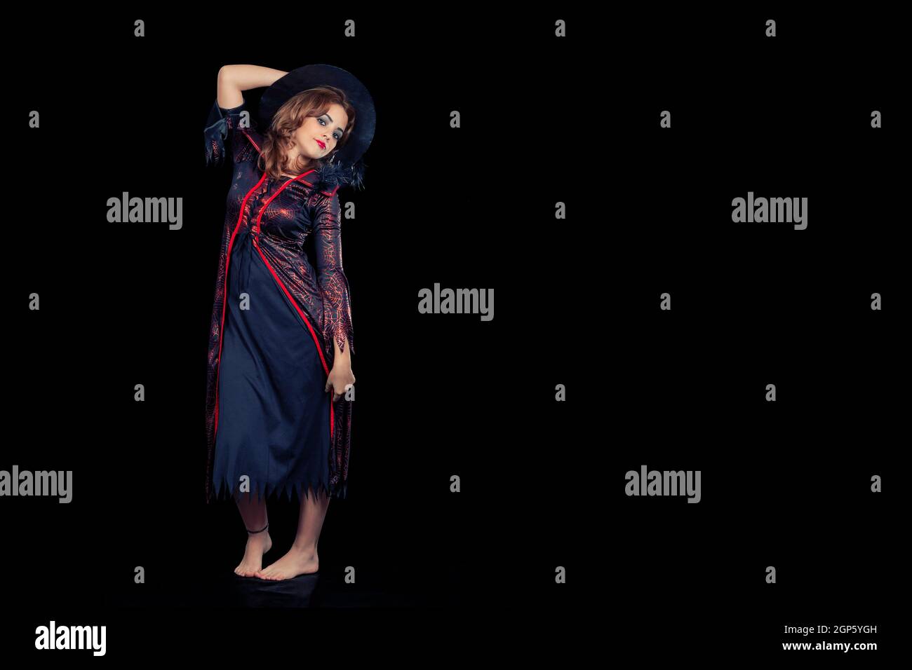 girl dressed as a witch portrayed on black background, wearing black ...