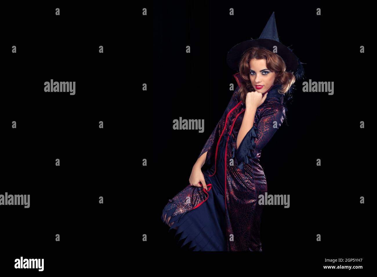 girl dressed as a witch portrayed on black background, wearing black ...