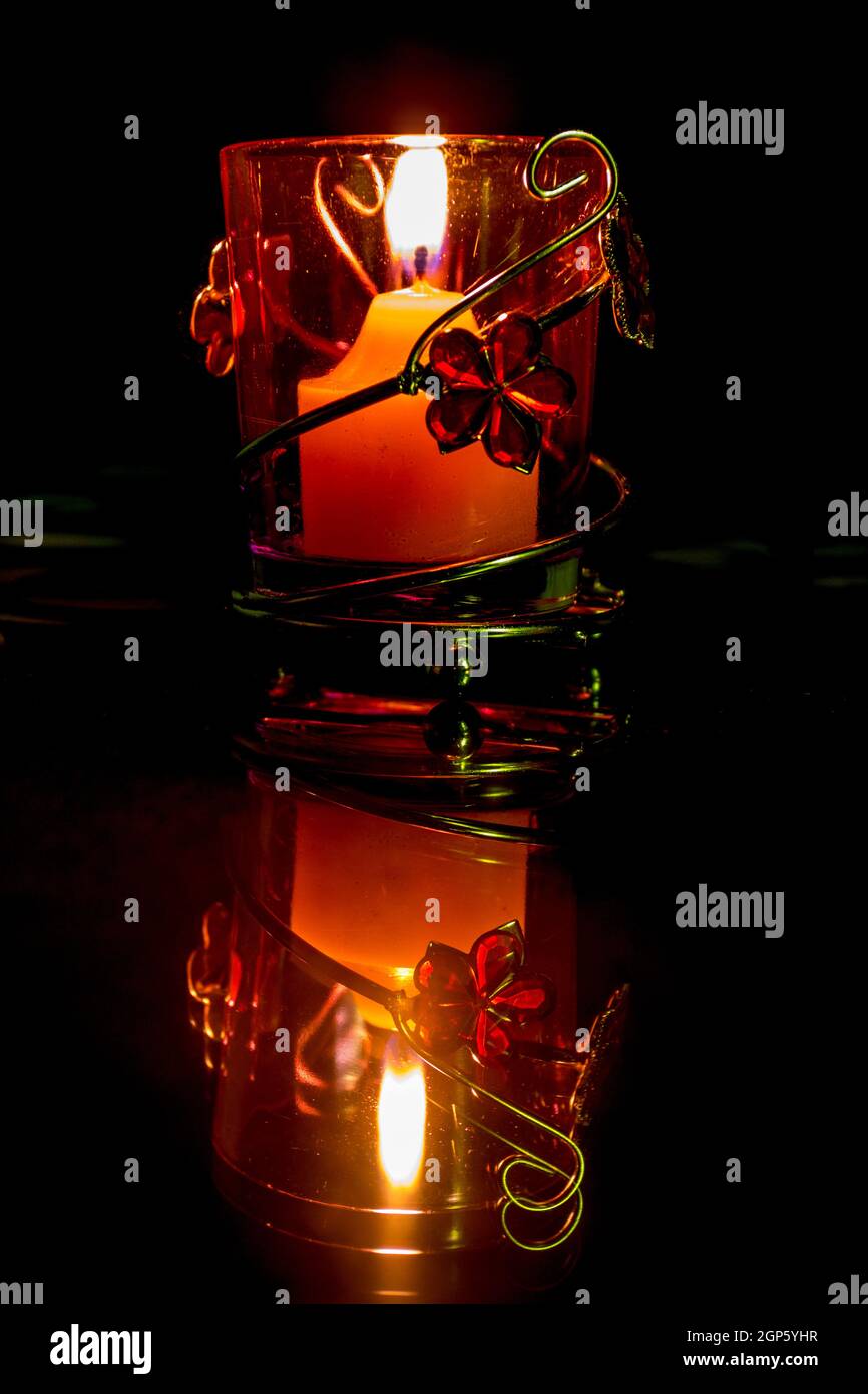 Candle. A turned on candle inside a crystal glass, on black background ...