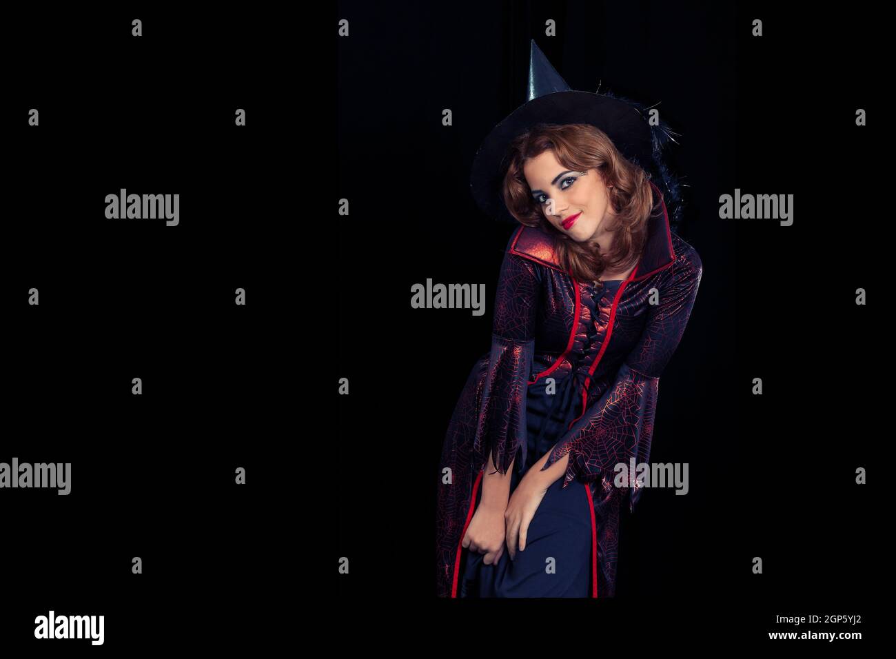 girl dressed as a witch portrayed on black background, wearing black ...