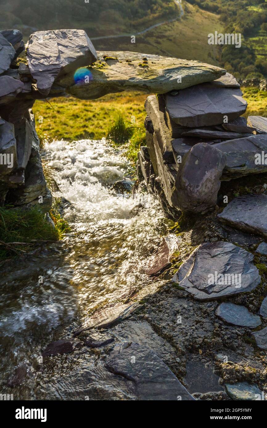 Cascading small stream that has flooded path after rain in through hole ...