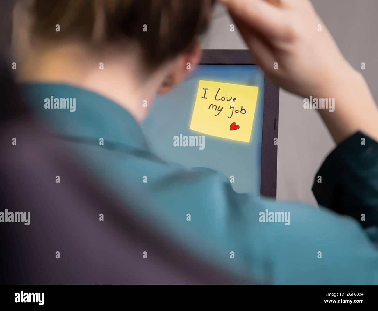 Business woman sitting in her home office with laptop and sticky note ...