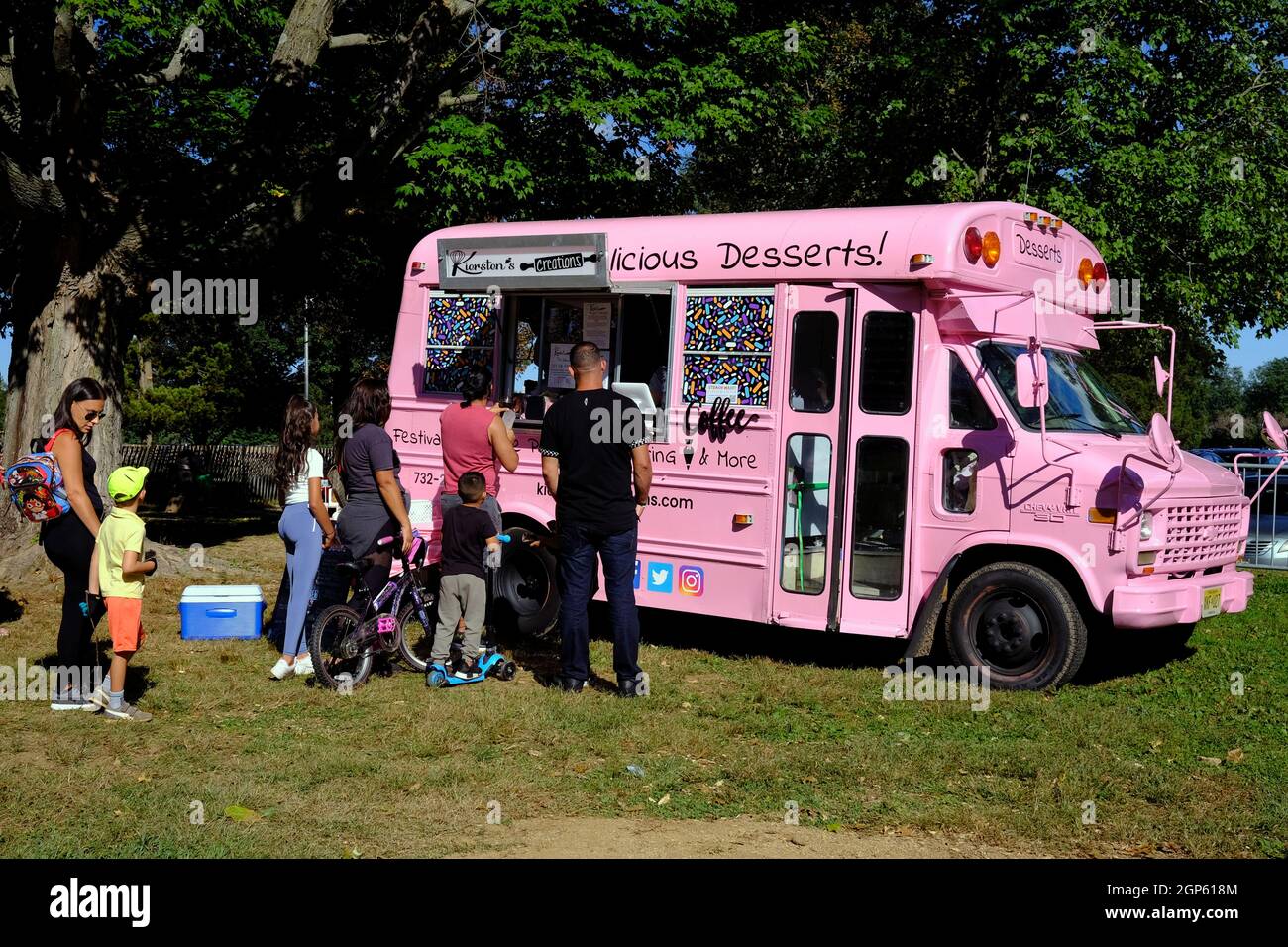 Pink Delicious Desserts Bus selling treats at a fair Stock Photo - Alamy