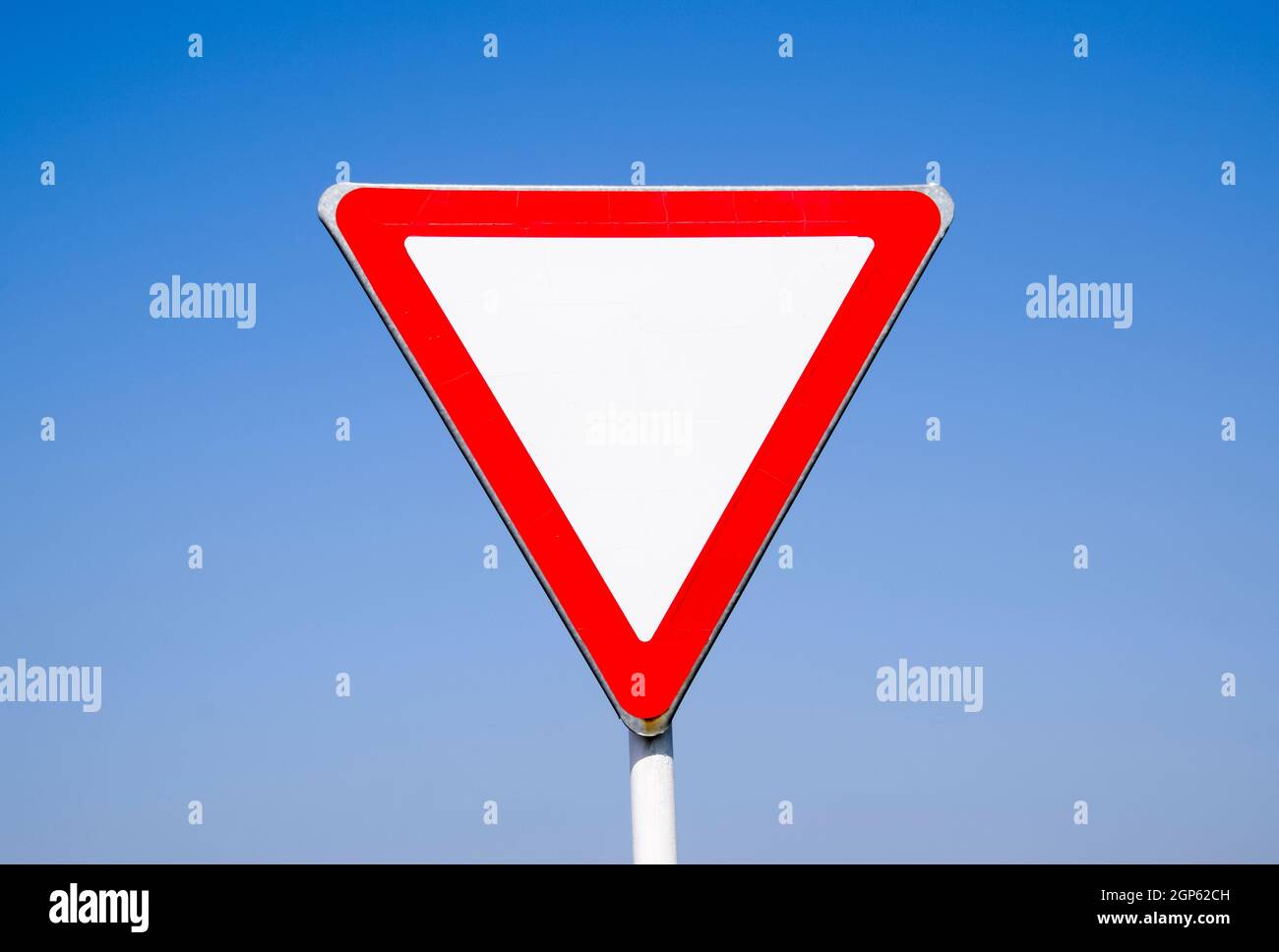 Road signs, give way. Sign on a blue background Stock Photo - Alamy