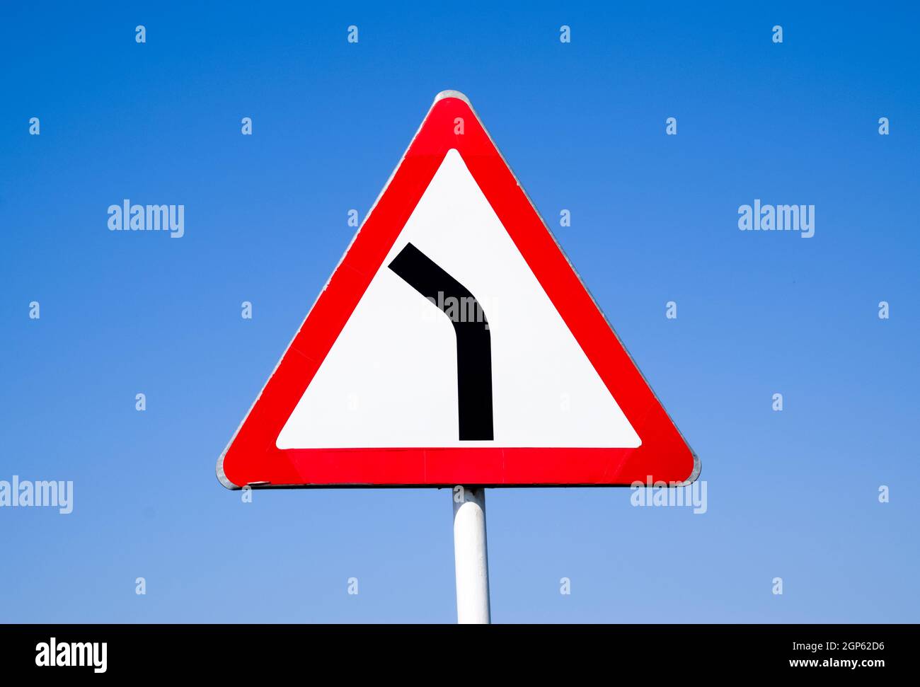 Road sign dangerous turn. Warning a sign Stock Photo - Alamy