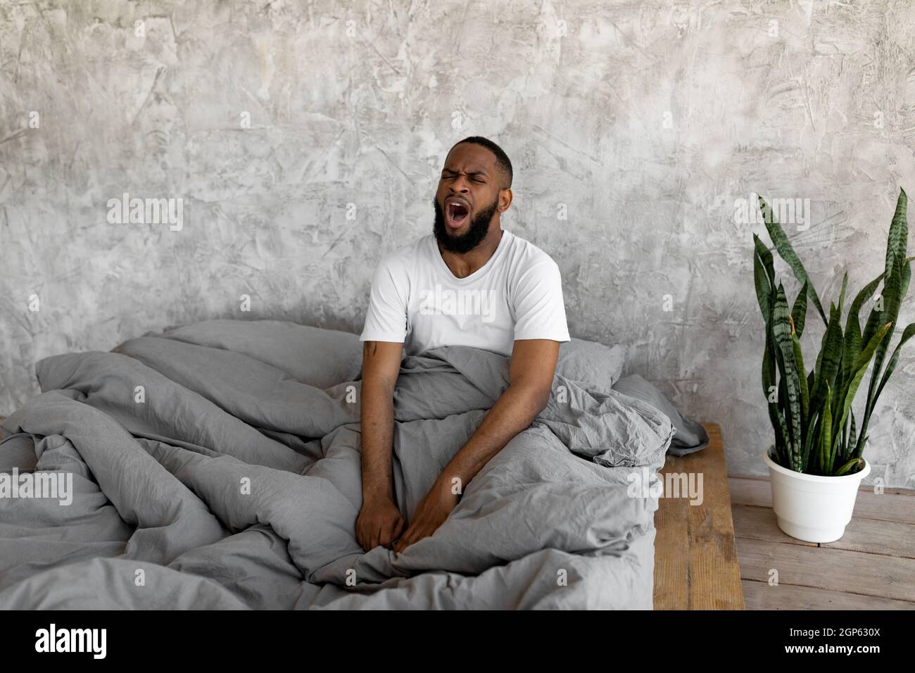 Portrait Of Sleepy Lazy African American Guy Yawning Waking Up Sitting