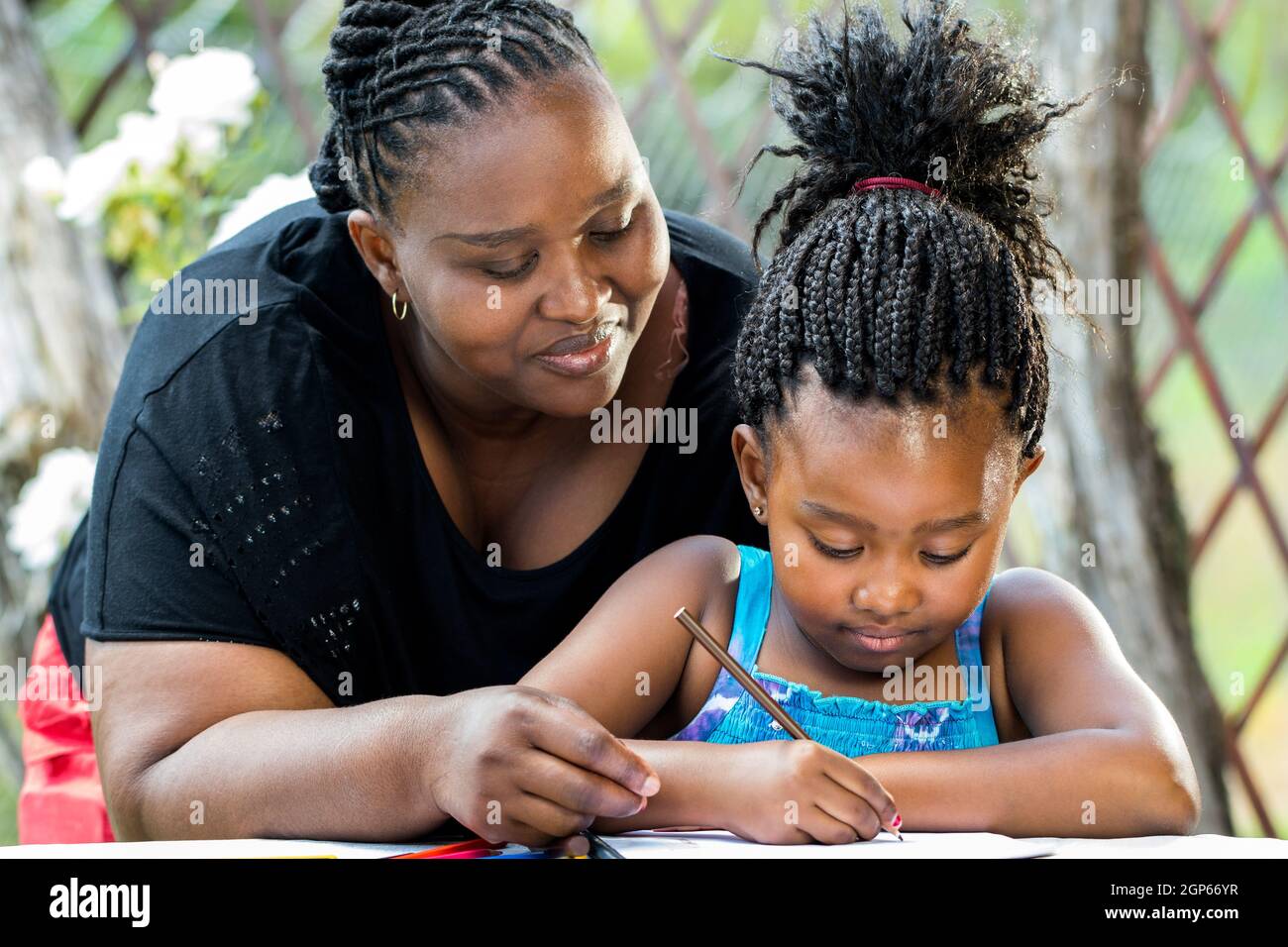 Close up portrait of african teacher supervising little kid doing ...