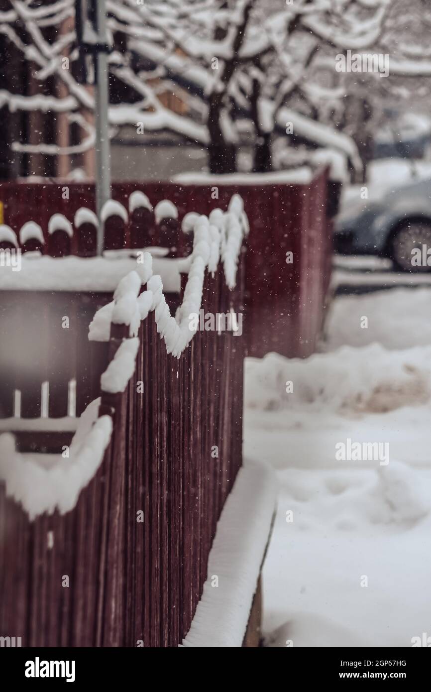 Wood red painted fence during winter heavy snow in Romania Stock Photo ...