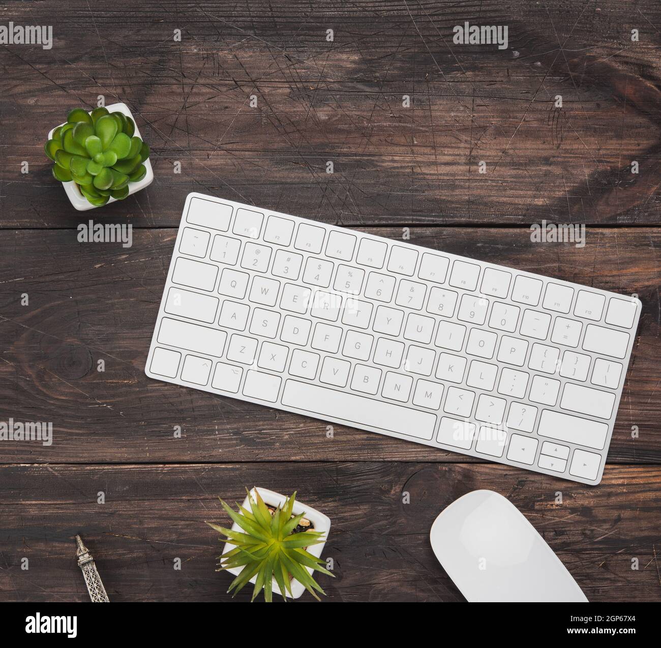white wireless keyboard and mouse on a wooden brown table, top view ...