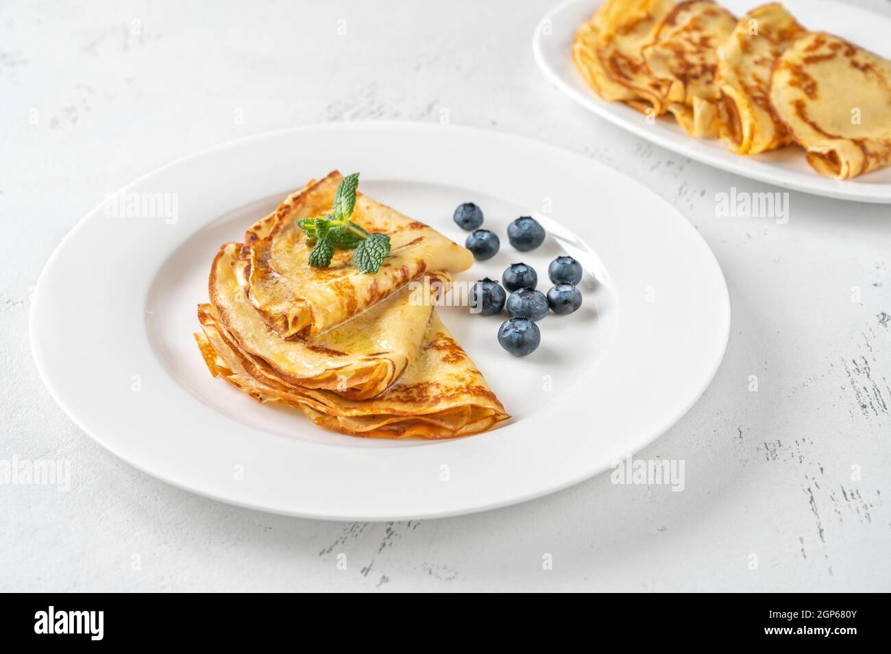 Folded crepes on the white serving plate Stock Photo - Alamy