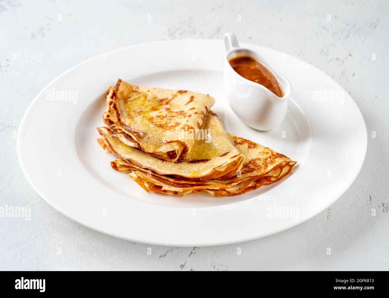 Folded crepes on the white serving plate Stock Photo - Alamy