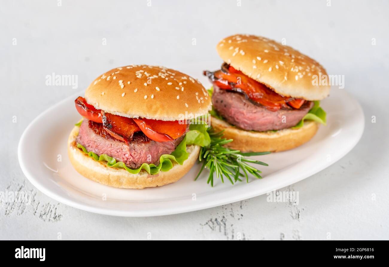Hamburgers with grilled pepper on the white serving plate Stock Photo ...
