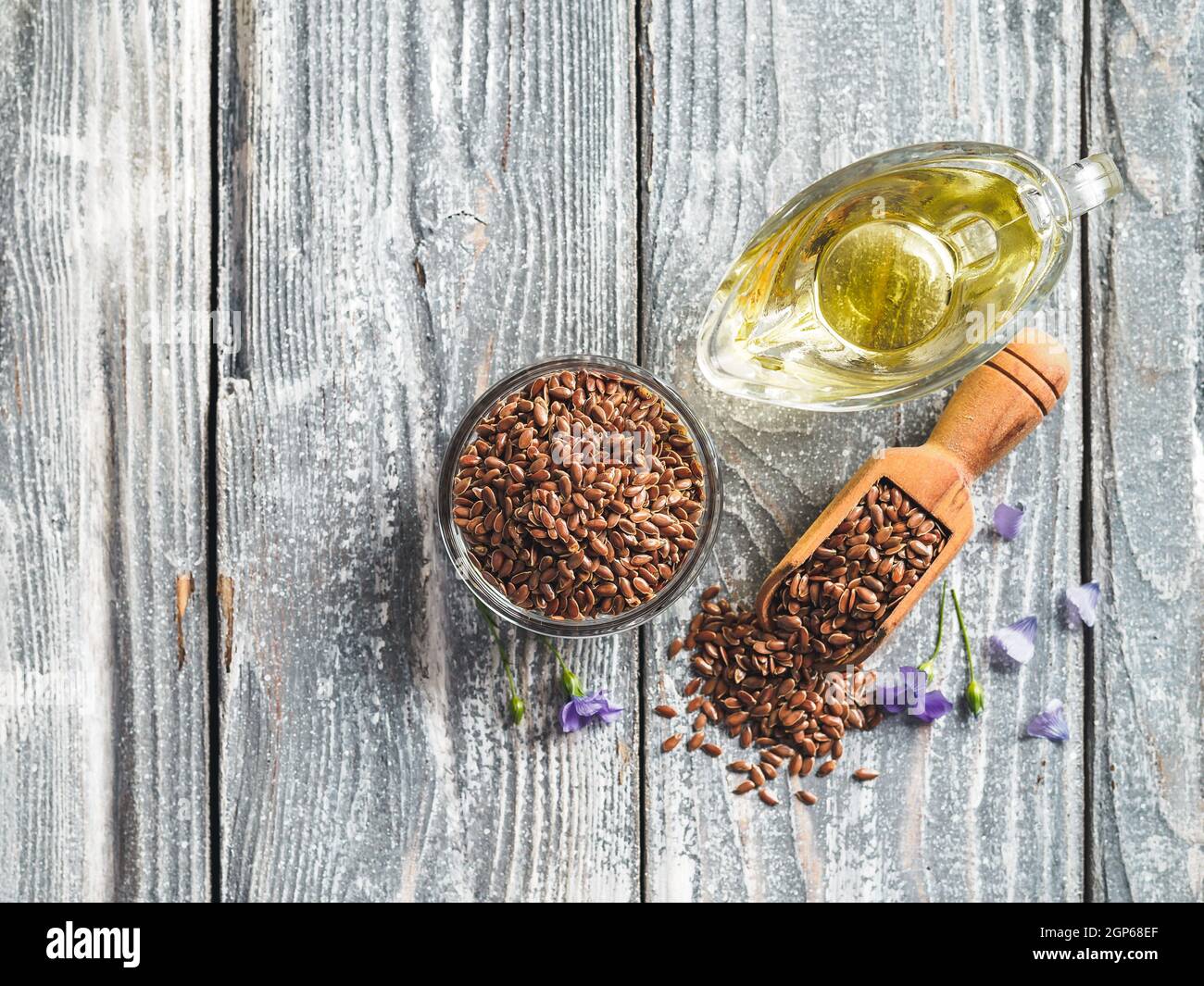 Flax seeds and flax oil. Brown linen seeds and flaxseed oil on old gray ...
